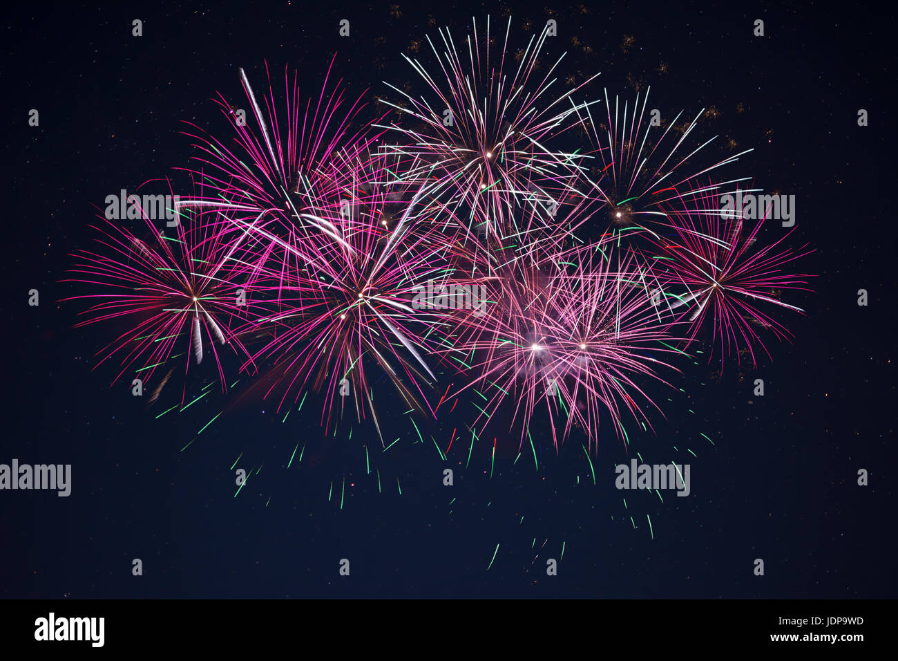 Sparkling maroon red pink celebration fireworks over starry sky ...