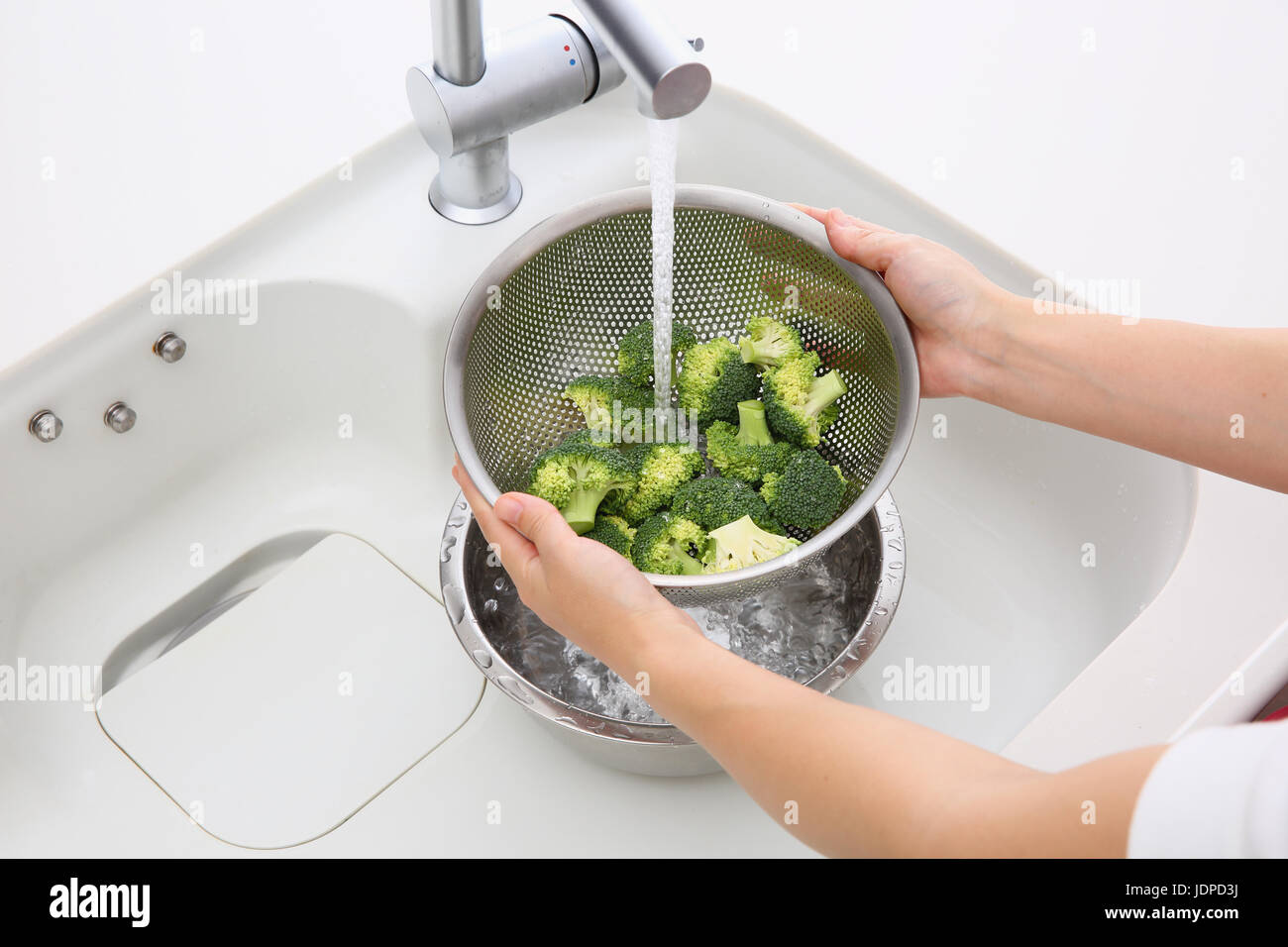 Japanese woman washing broccoli in the kitchen Stock Photo - Alamy