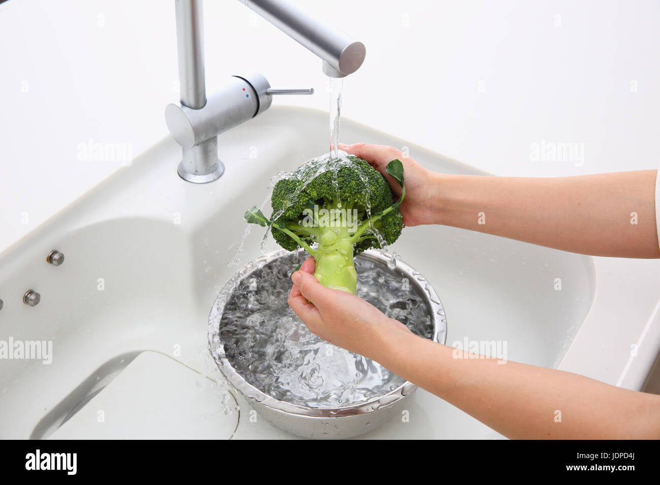 Japanese woman washing broccoli in the kitchen Stock Photo - Alamy