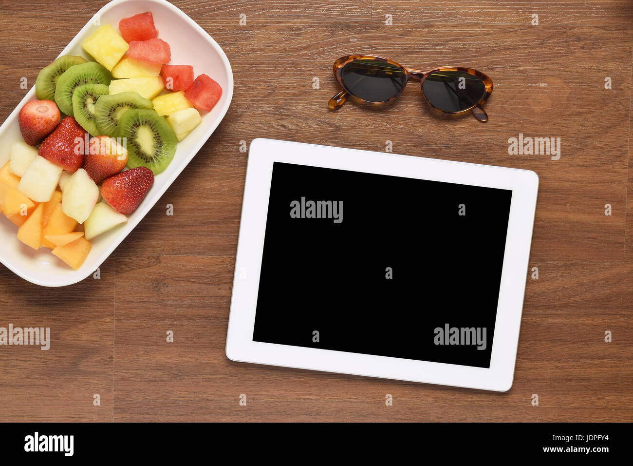 Top view of healthy summer snack and tablet gadget on wooden table ...