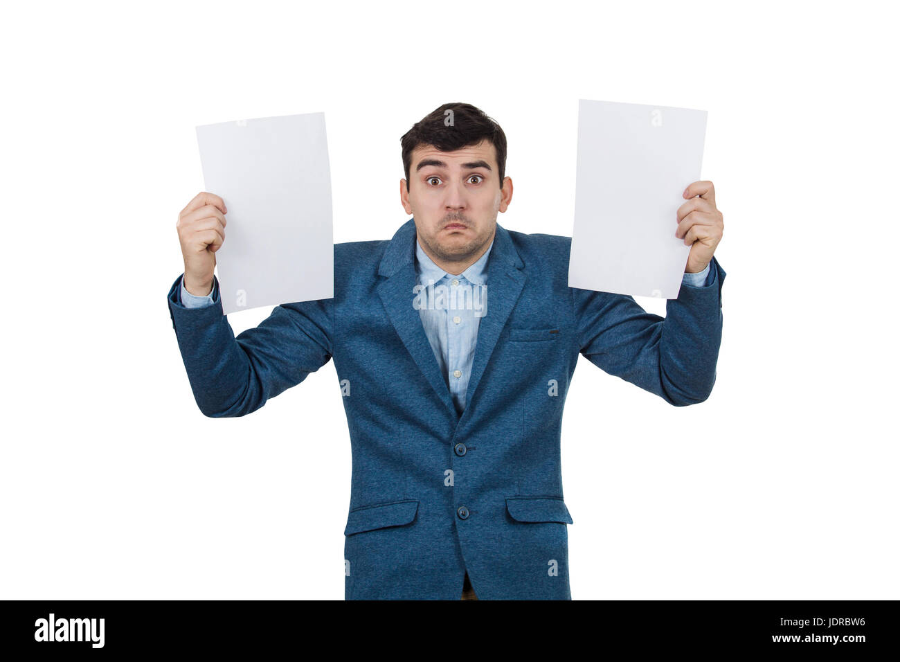 Confused young businessman holding two white papers in hands, isolated ...