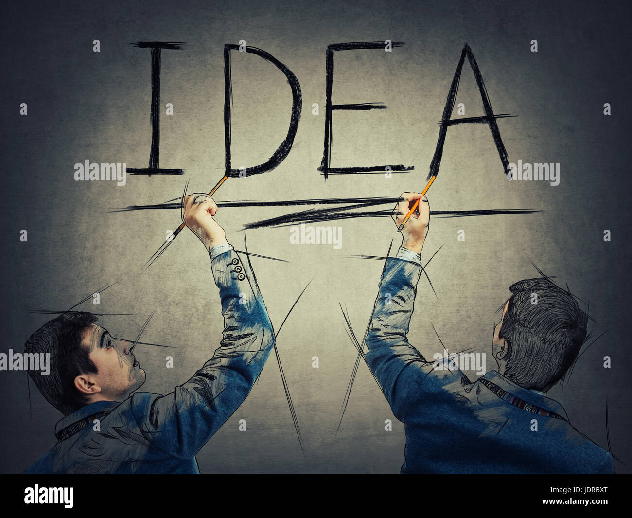 Young businessman in different poses drawing idea text on a gray wall ...