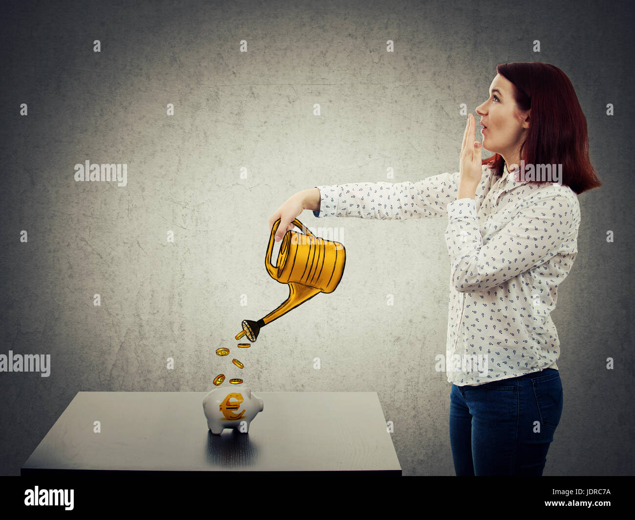 Surprised young woman with a watering can in her hand pouring a money ...
