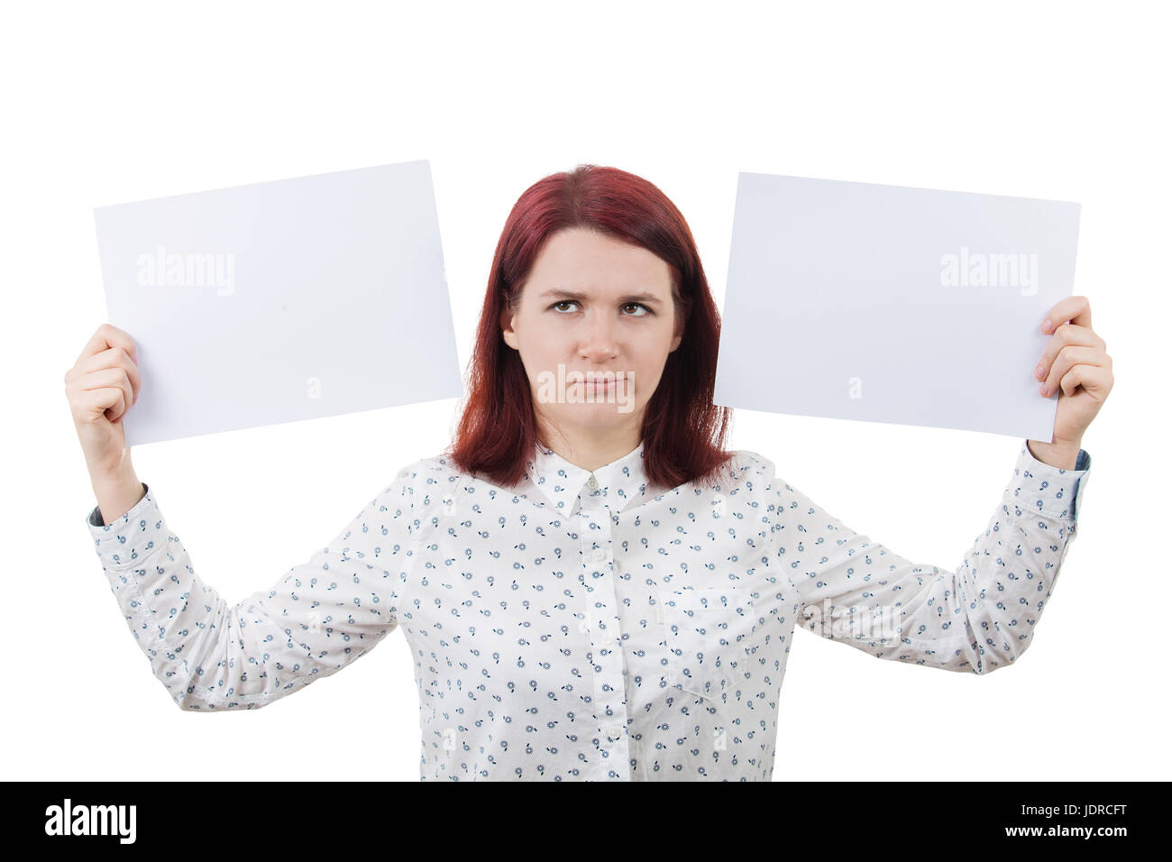 Confused young woman holding two white papers in hands, isolated on ...
