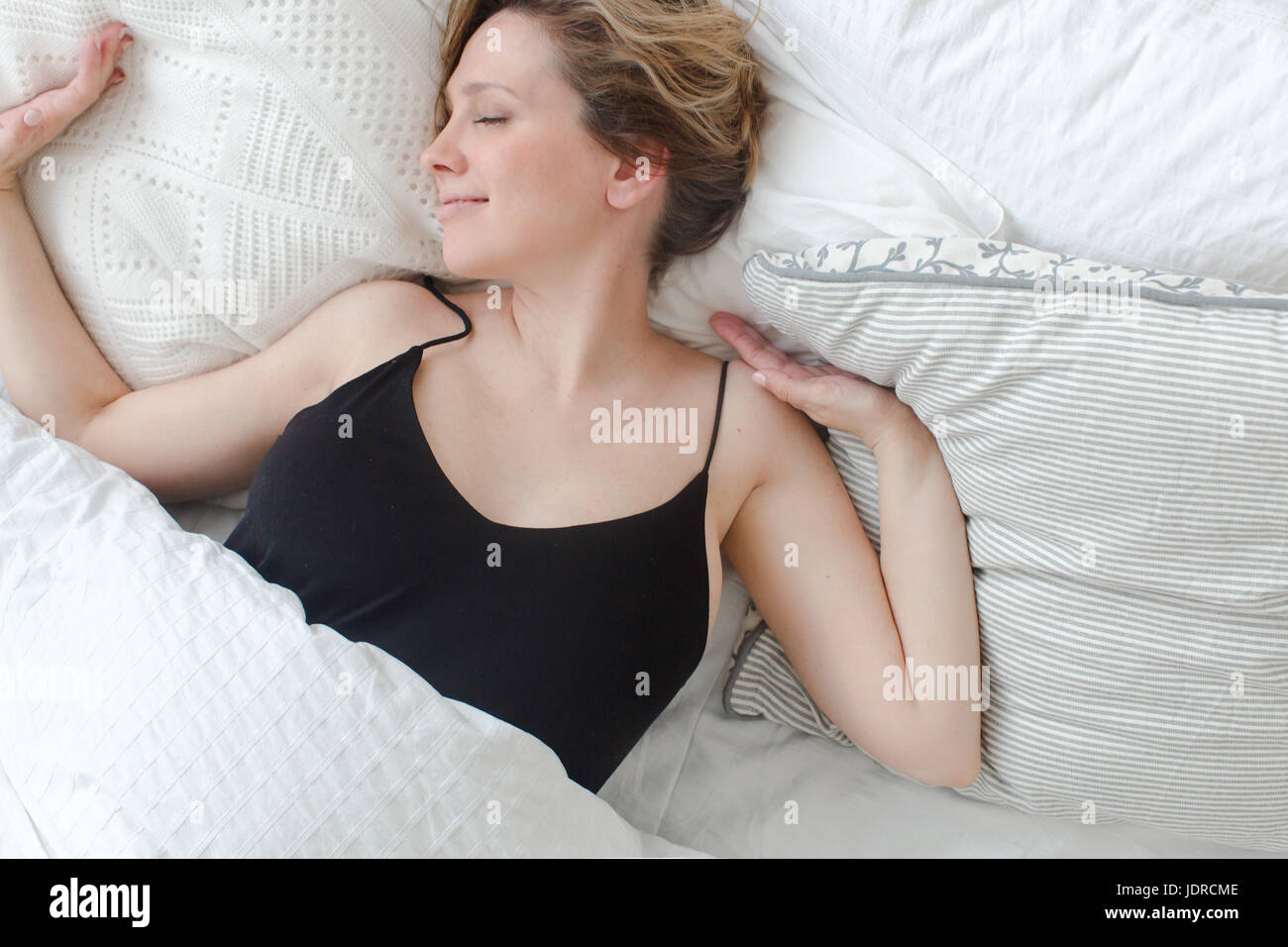 Young woman relaxing in bed Stock Photo - Alamy
