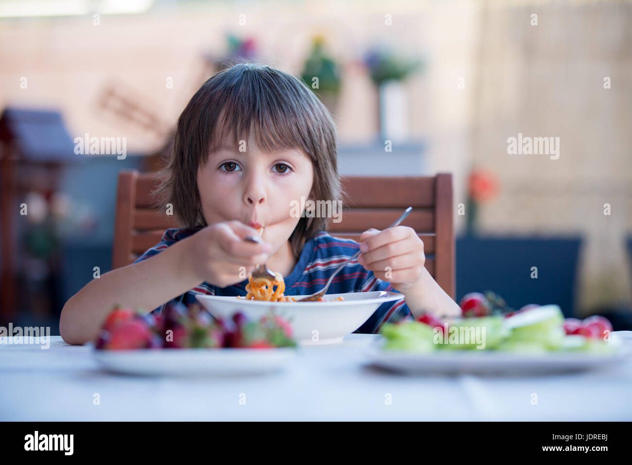 Cute child, preschool boy, eating spaghetti for lunch outdoors in ...