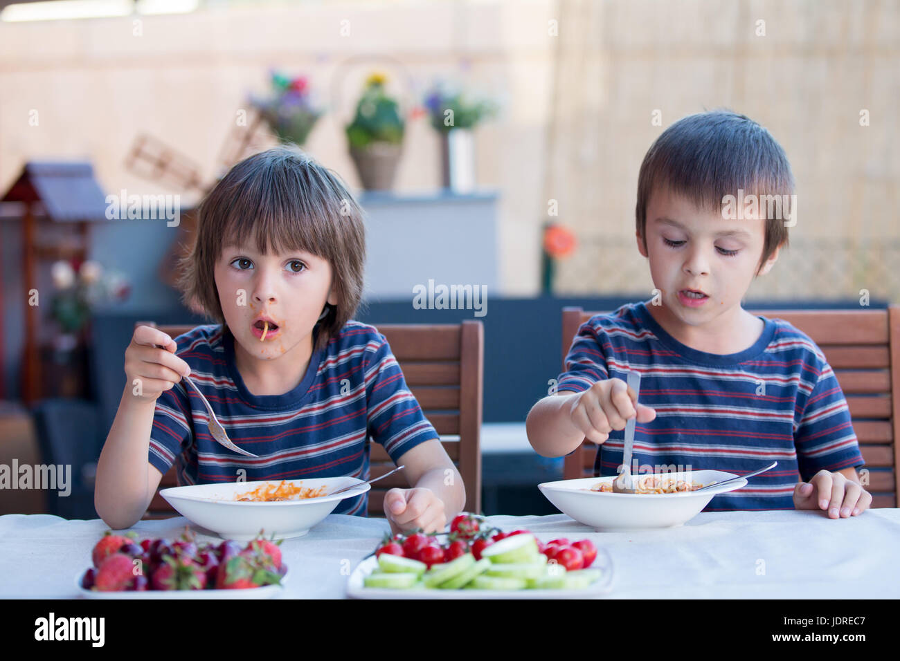 Cute children, preschool boys, eating spaghetti for lunch outdoors in ...