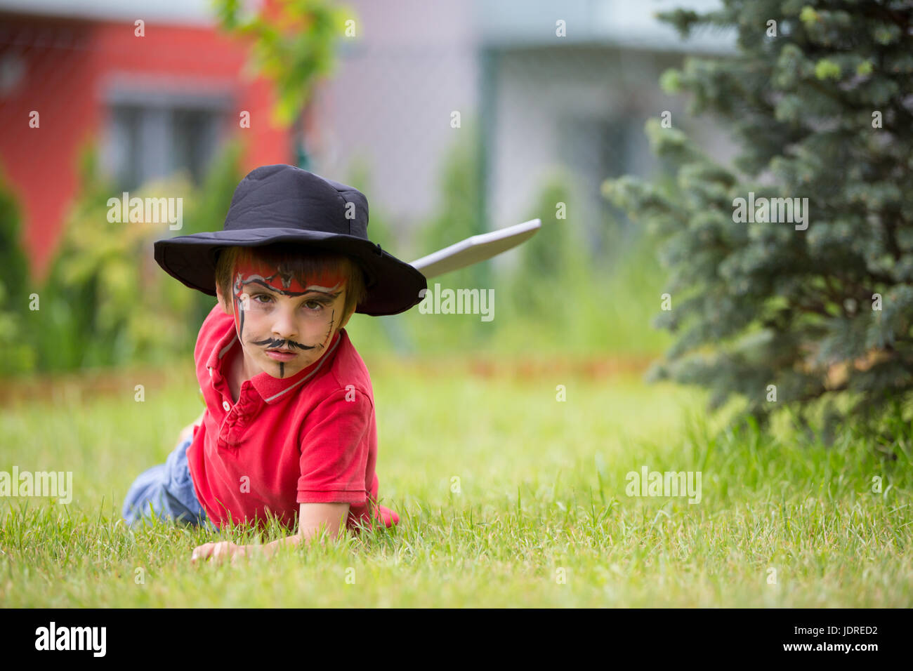 Cute school boy, playing games, painted as pirate, holding sword, play ...