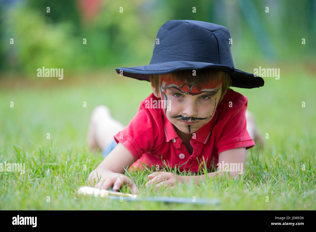 Cute school boy, playing games, painted as pirate, holding sword, play ...