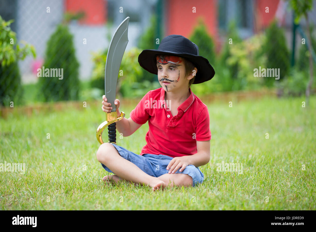 Cute school boy, playing games, painted as pirate, holding sword, play ...