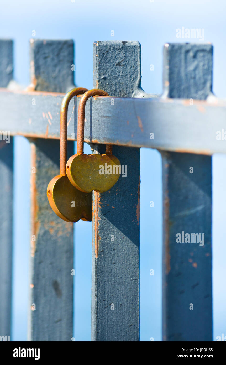 Padlocks hanging on the metal fence. Closeup Stock Photo - Alamy