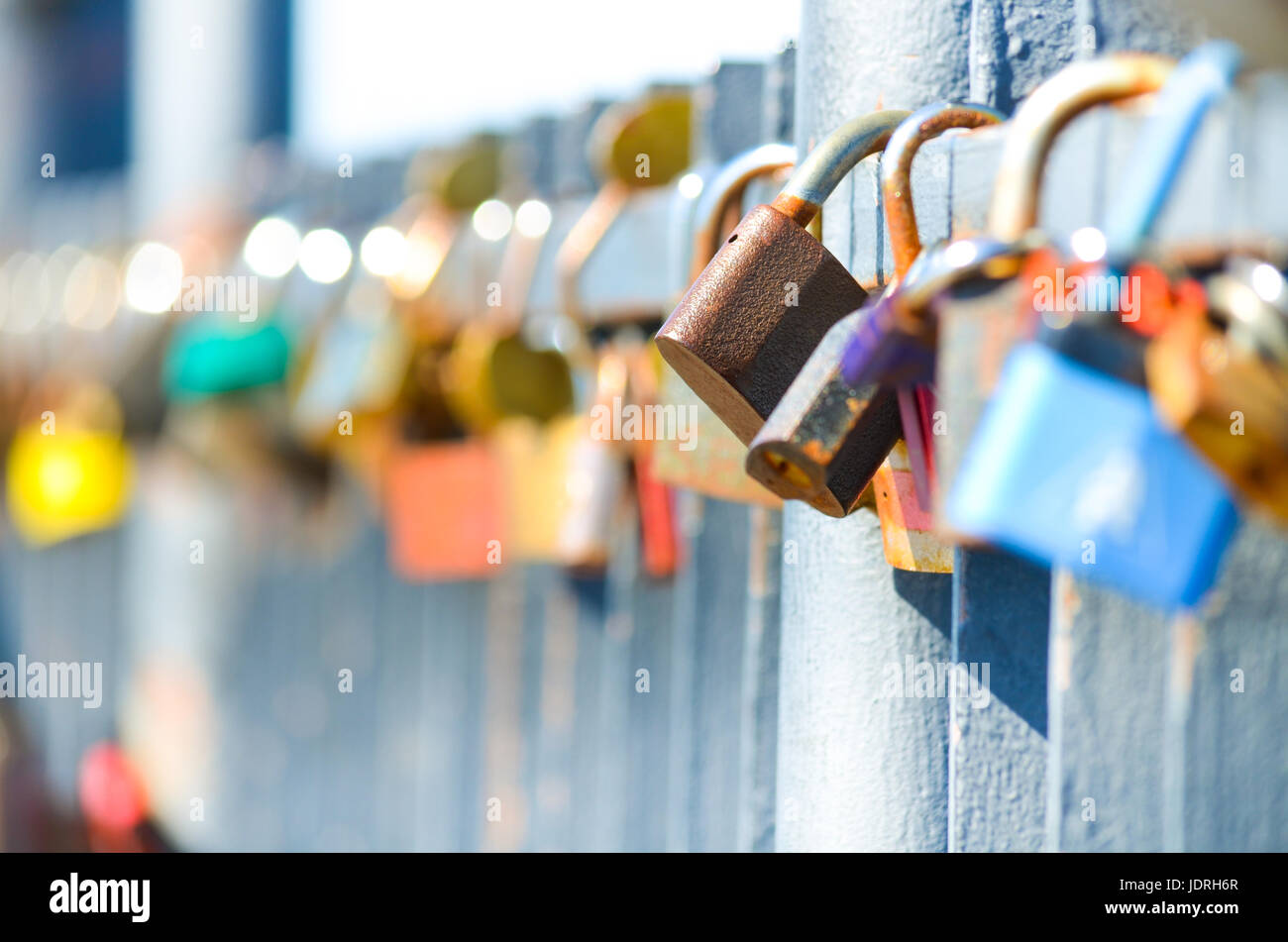 Many padlocks hanging on the metal fence. Closeup Stock Photo - Alamy