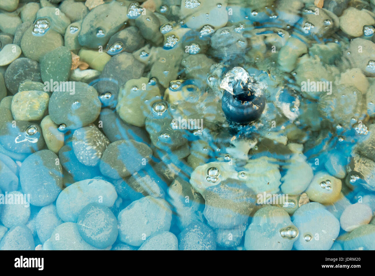 A water drop over river rocks Stock Photo - Alamy