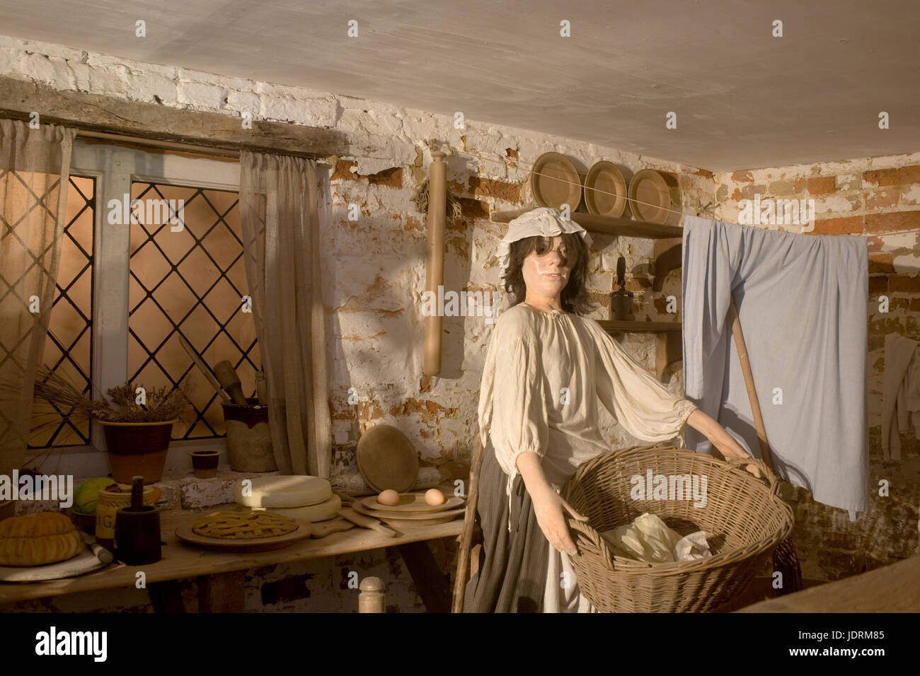 Interior of shipwright's cottage with his wife doing laundry at Buckler ...