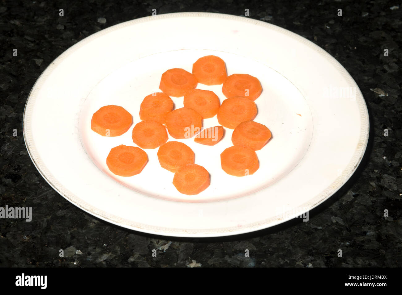 Sliced carrot on white plate on kitchen surface Stock Photo - Alamy