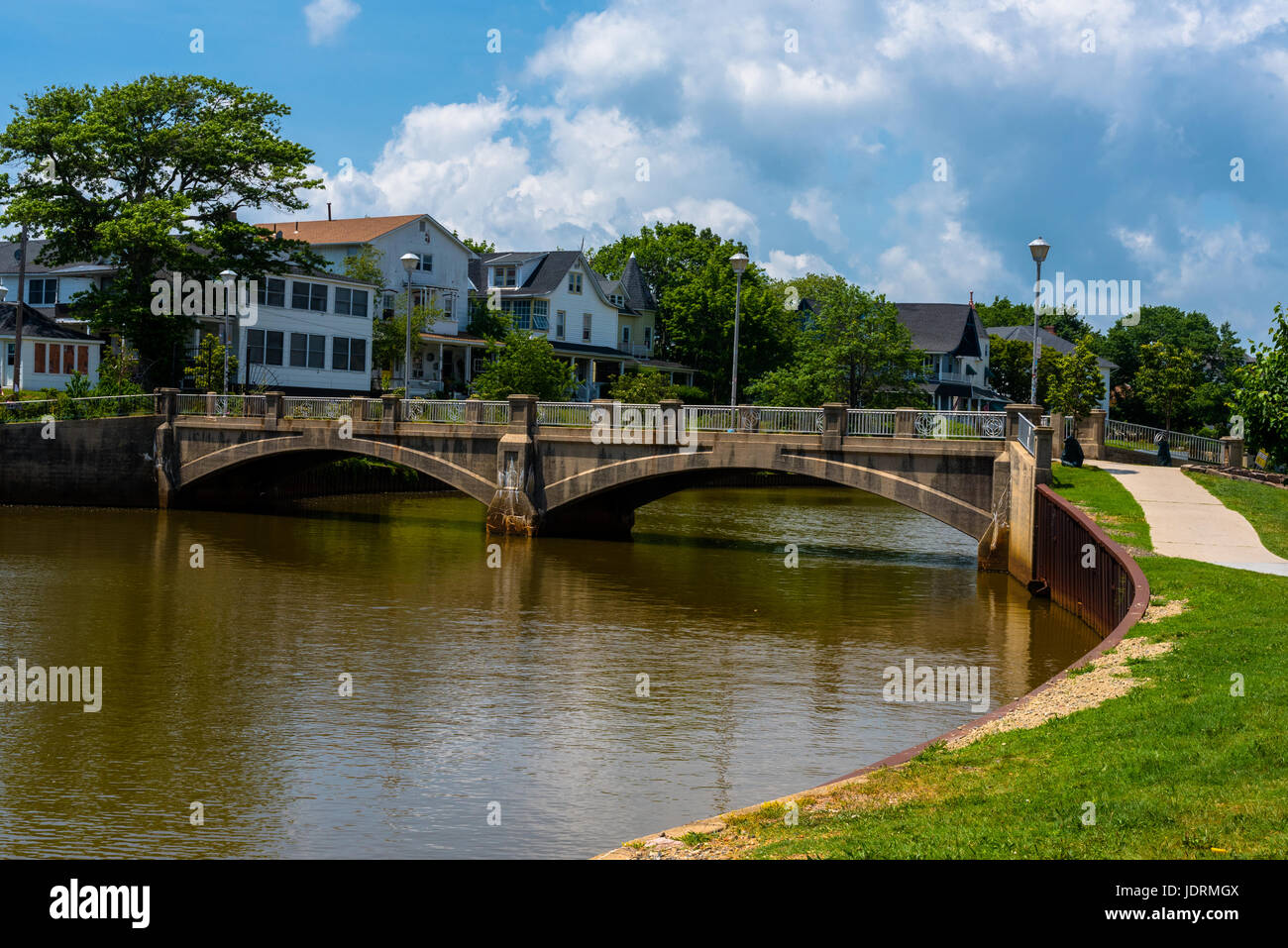 A small bridge with water from a lake flowing beneath Stock Photo - Alamy