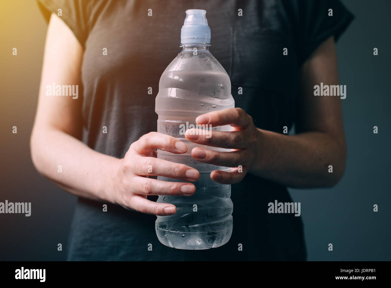 Woman with bottle of fresh drinking water for refreshment and ...