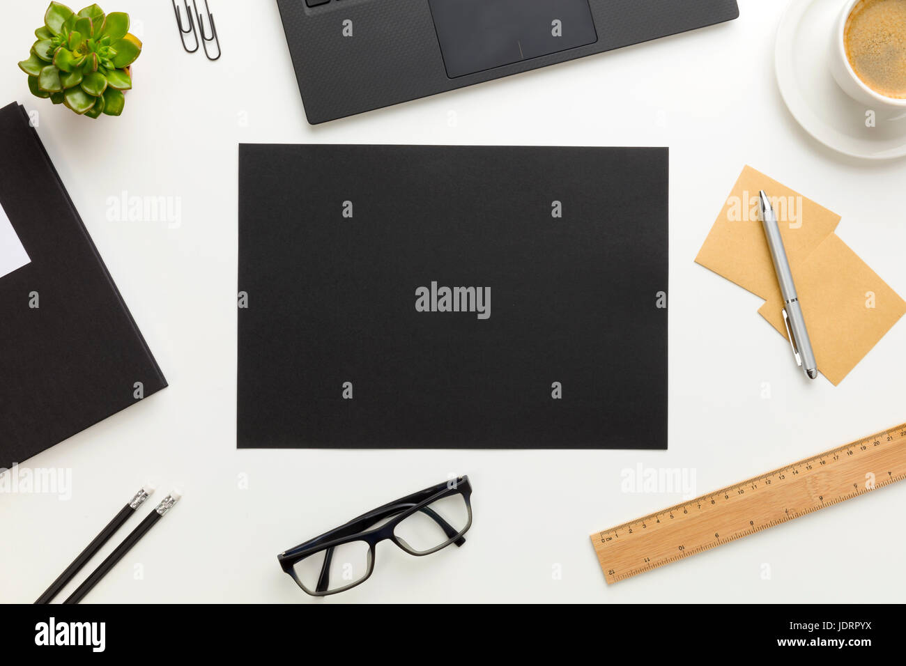 Top view of modern white office desk with black paper in center Stock ...