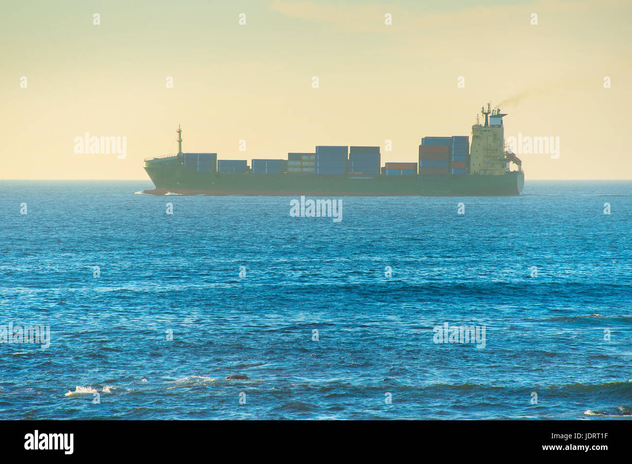 Industrial tanker full of containers in the ocean at sunset Stock Photo ...