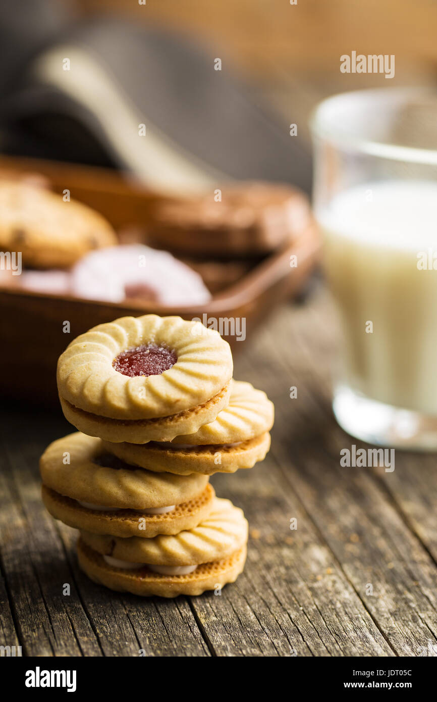 Sweet biscuits with jam on old wooden table Stock Photo - Alamy