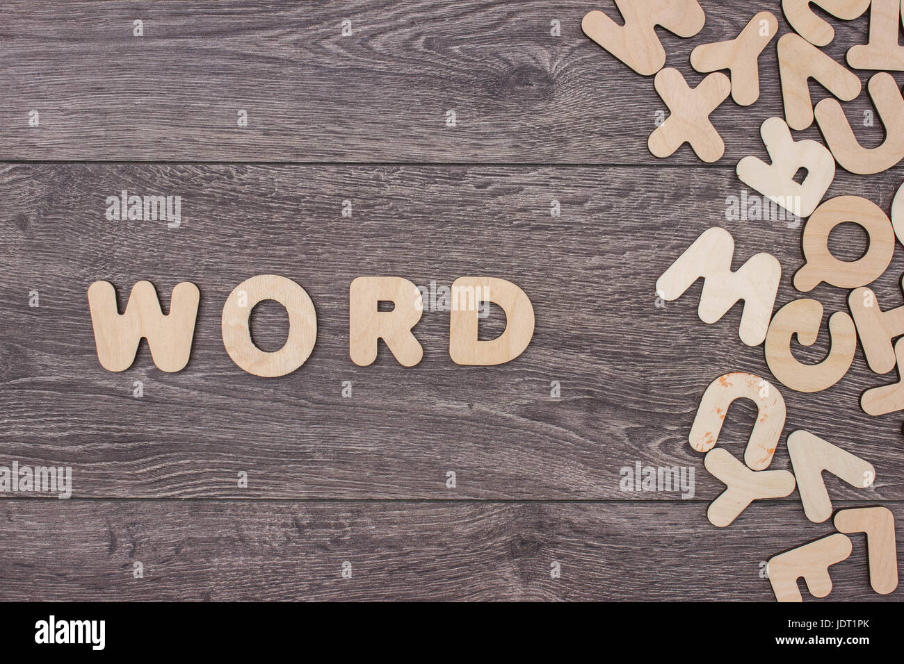 Word word made with block wooden letters next to a pile of other ...