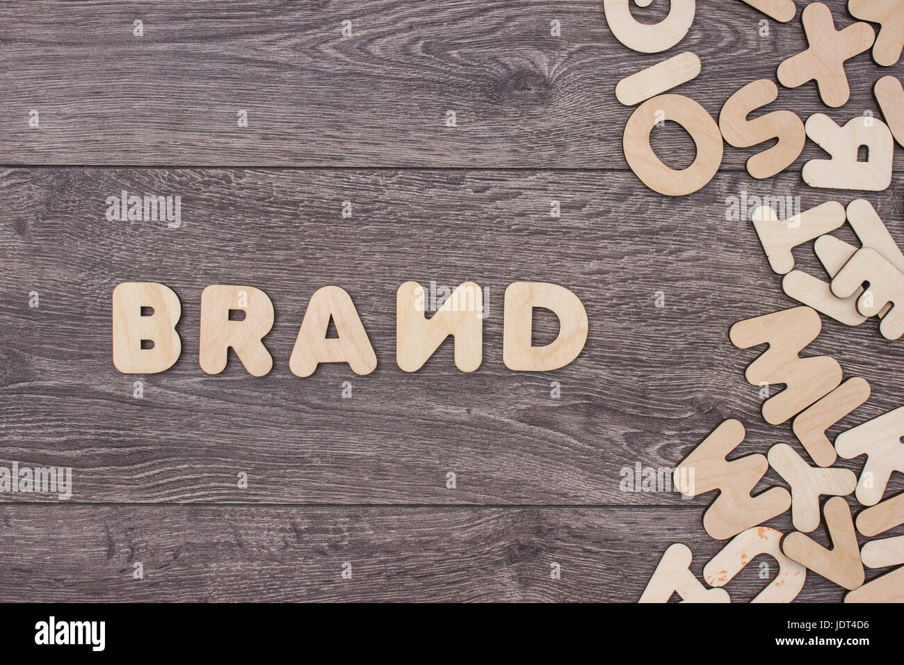 Word Brand made with wooden letters next to a pile of other letters ...