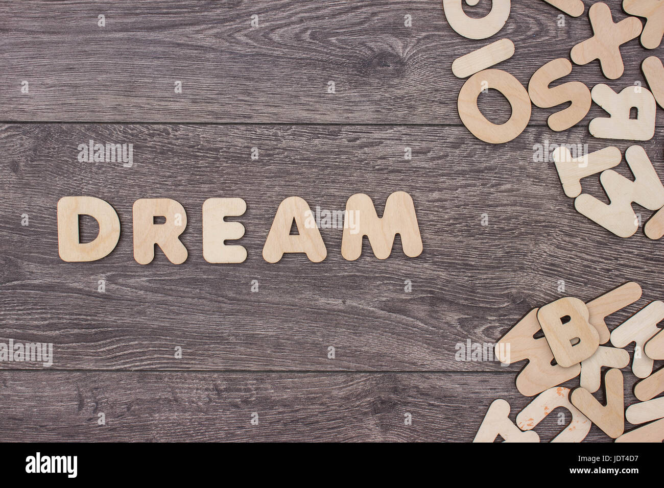 Word Dream made with wooden letters next to a pile of other letters ...