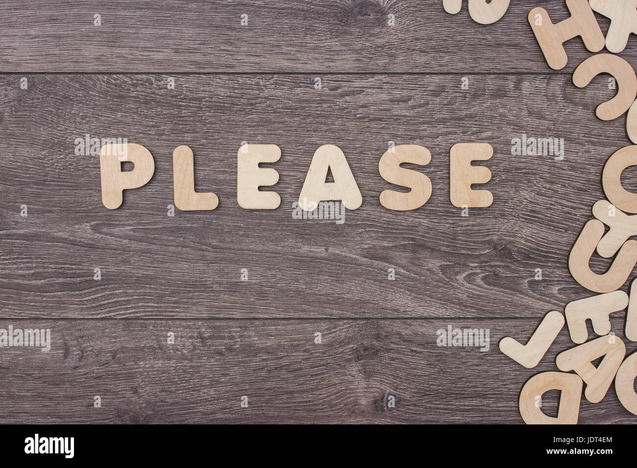 Word Please made with wooden letters next to a pile of other letters ...