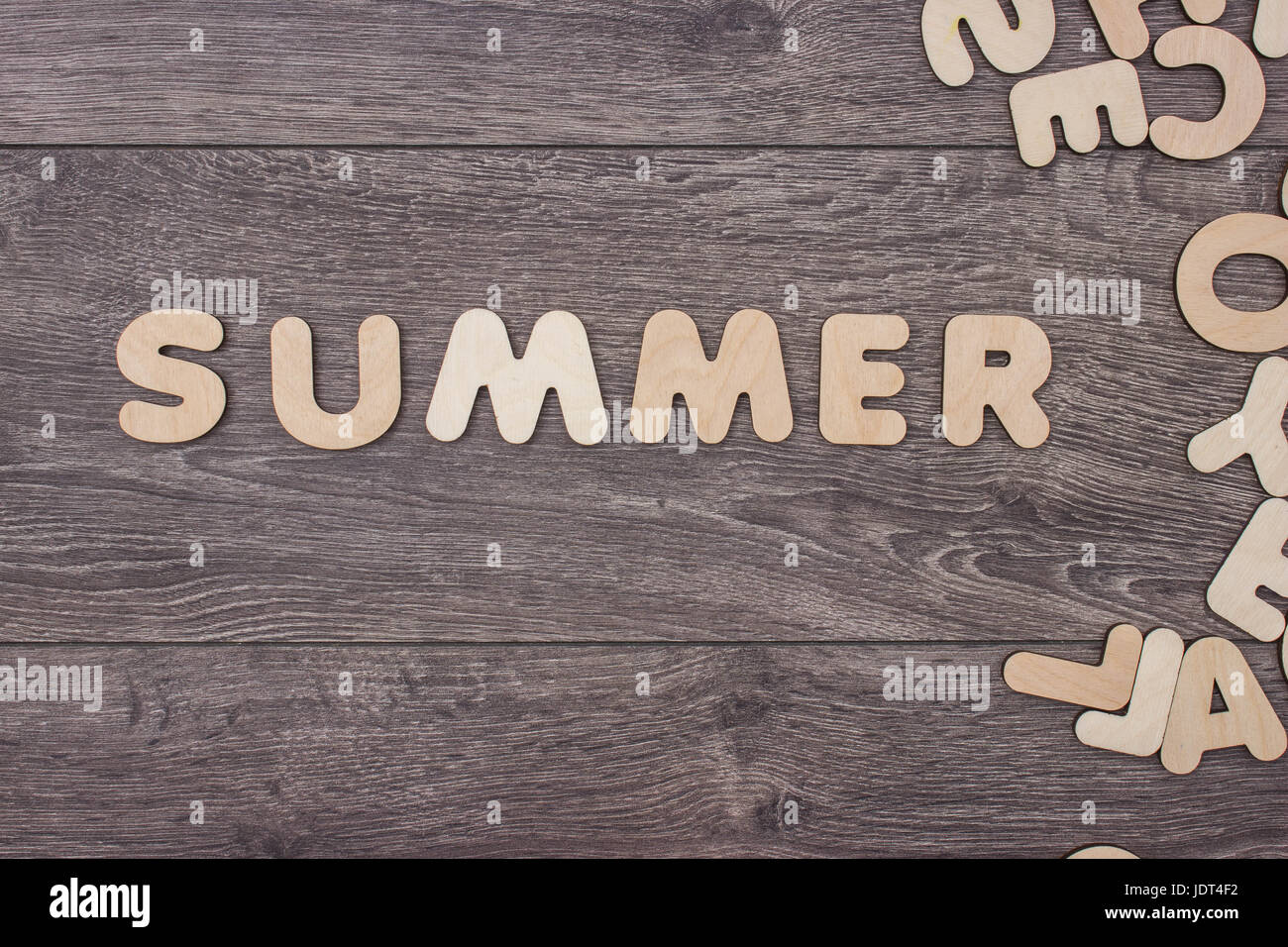 Word Summer made with wooden letters next to a pile of other letters ...
