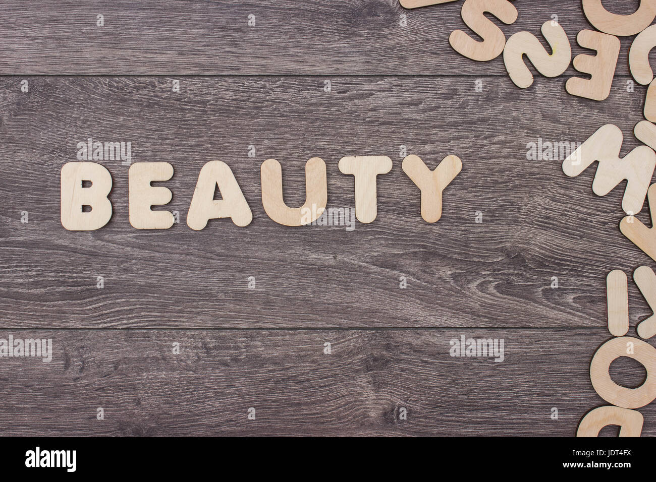 Word Beauty made with wooden letters next to a pile of other letters ...