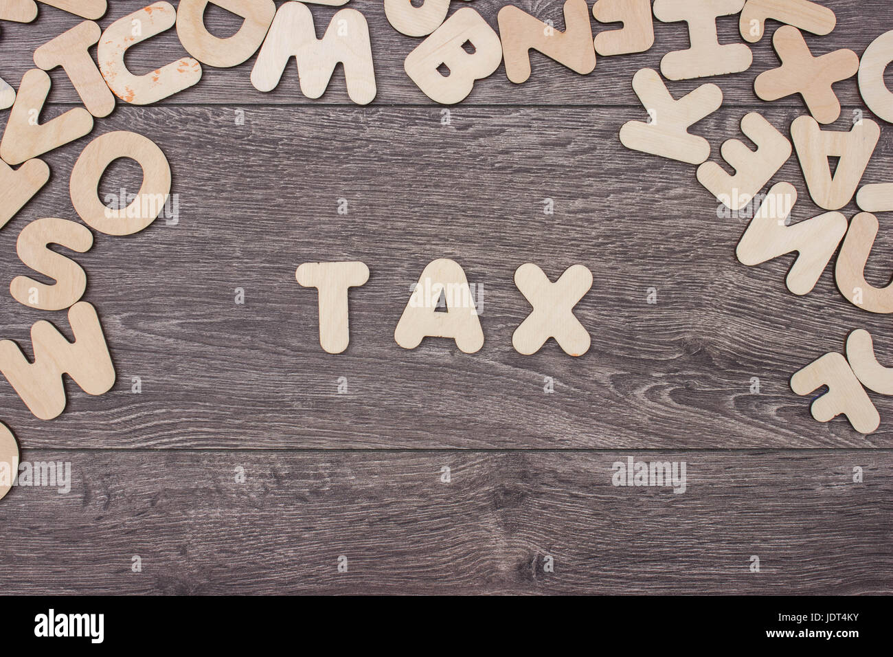 Word Tax made with wooden letters next to a pile of other letters over ...