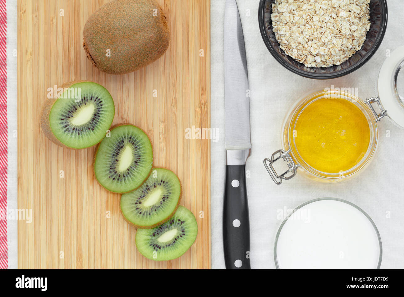 Cooking health breakfast with fresh sliced kiwi, milk, oatmeal. Top ...