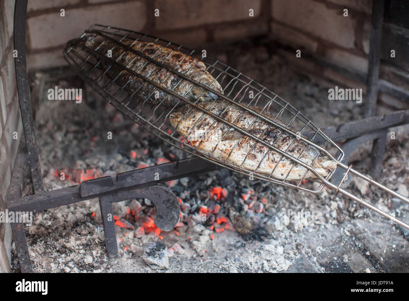 Appetizing fish in a steel grid, fried on the grill Stock Photo - Alamy