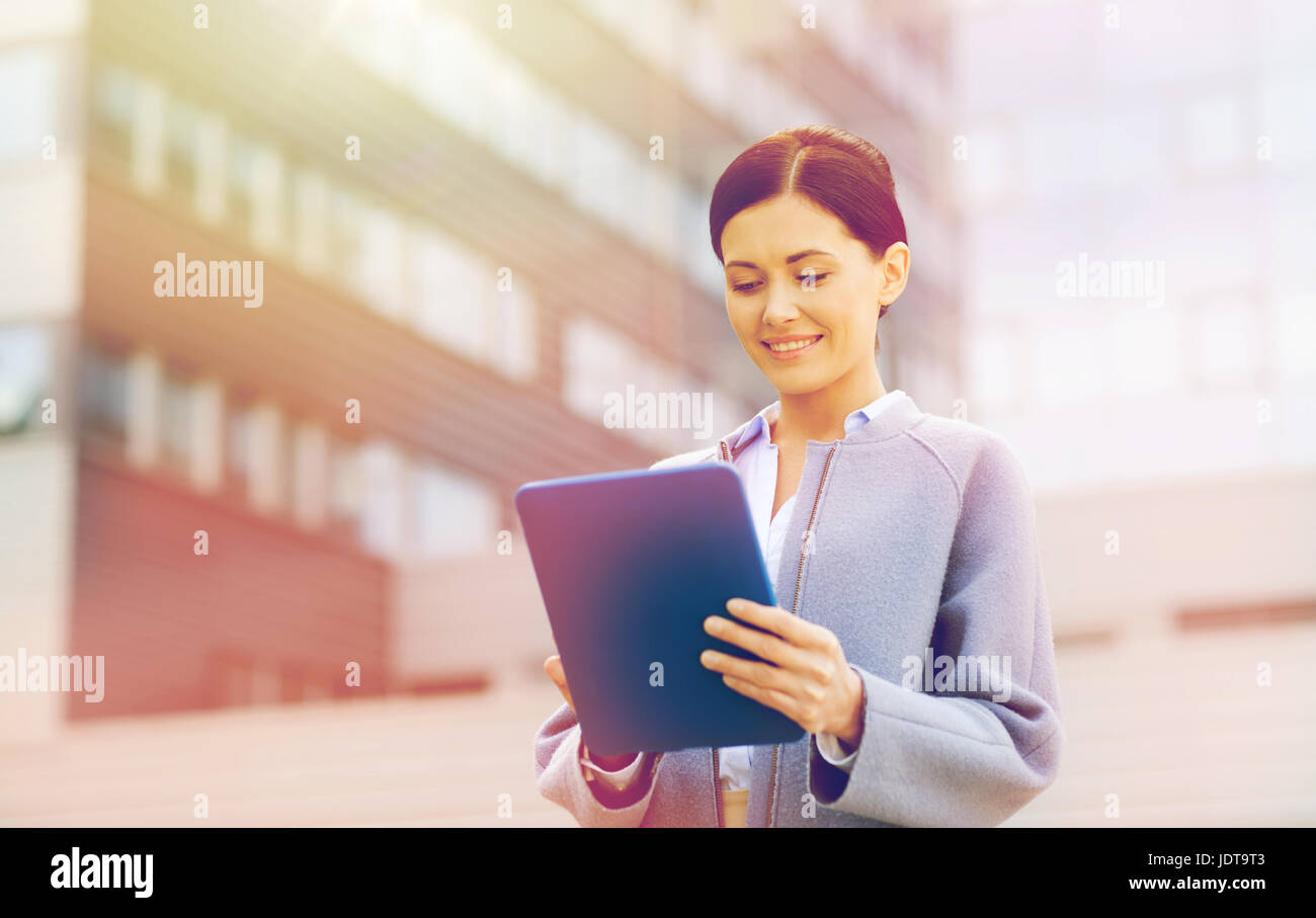 smiling business woman with tablet pc in city Stock Photo - Alamy