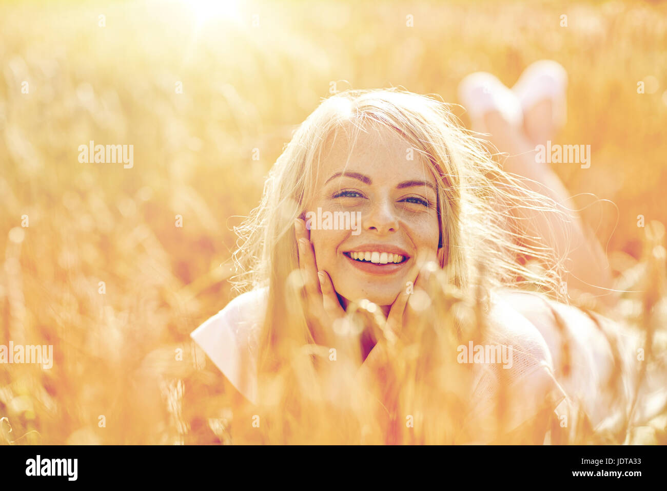 happy woman or teen girl lying in cereal field Stock Photo - Alamy