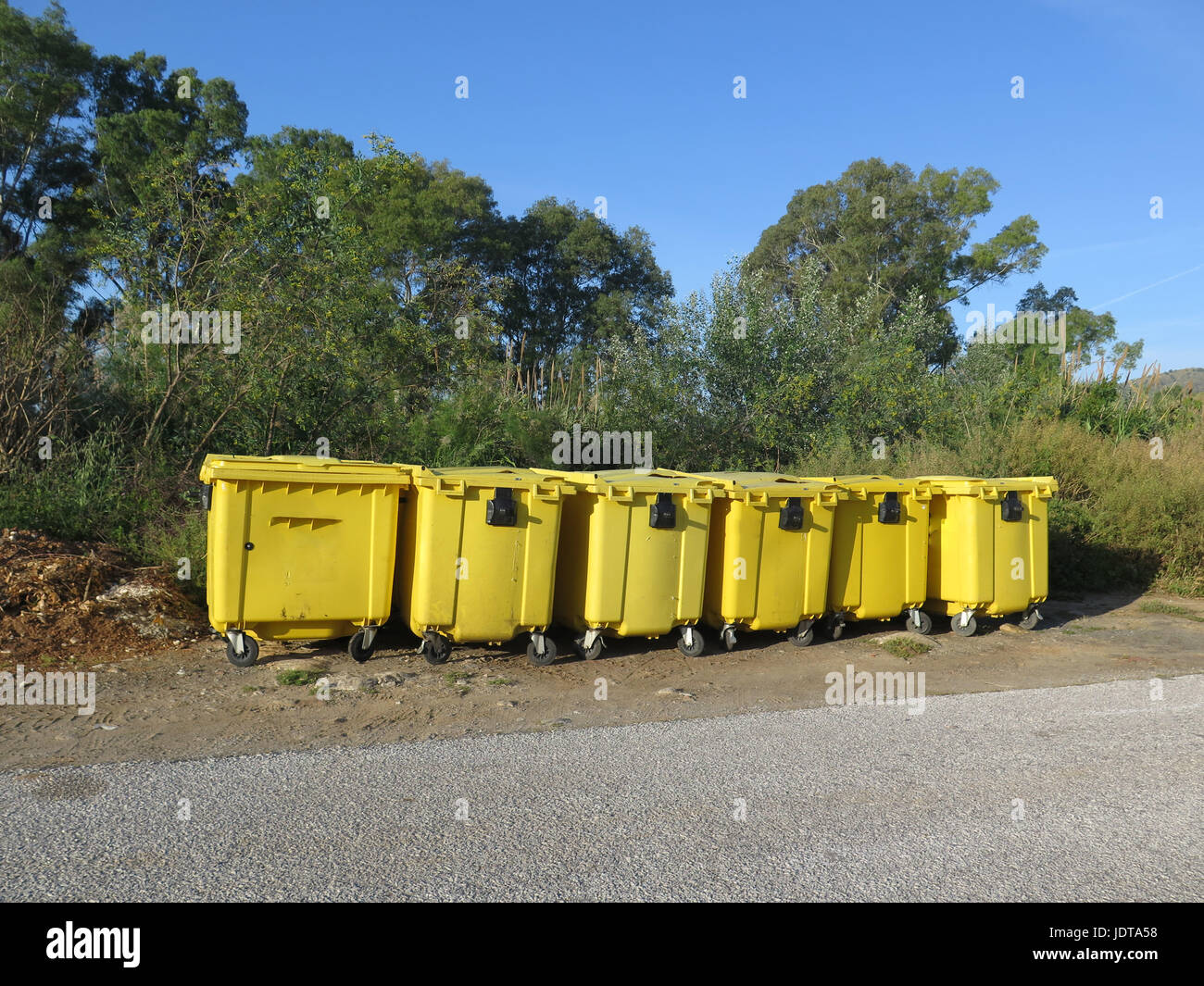 Collection of yellow recycling containers on rural road side Stock ...