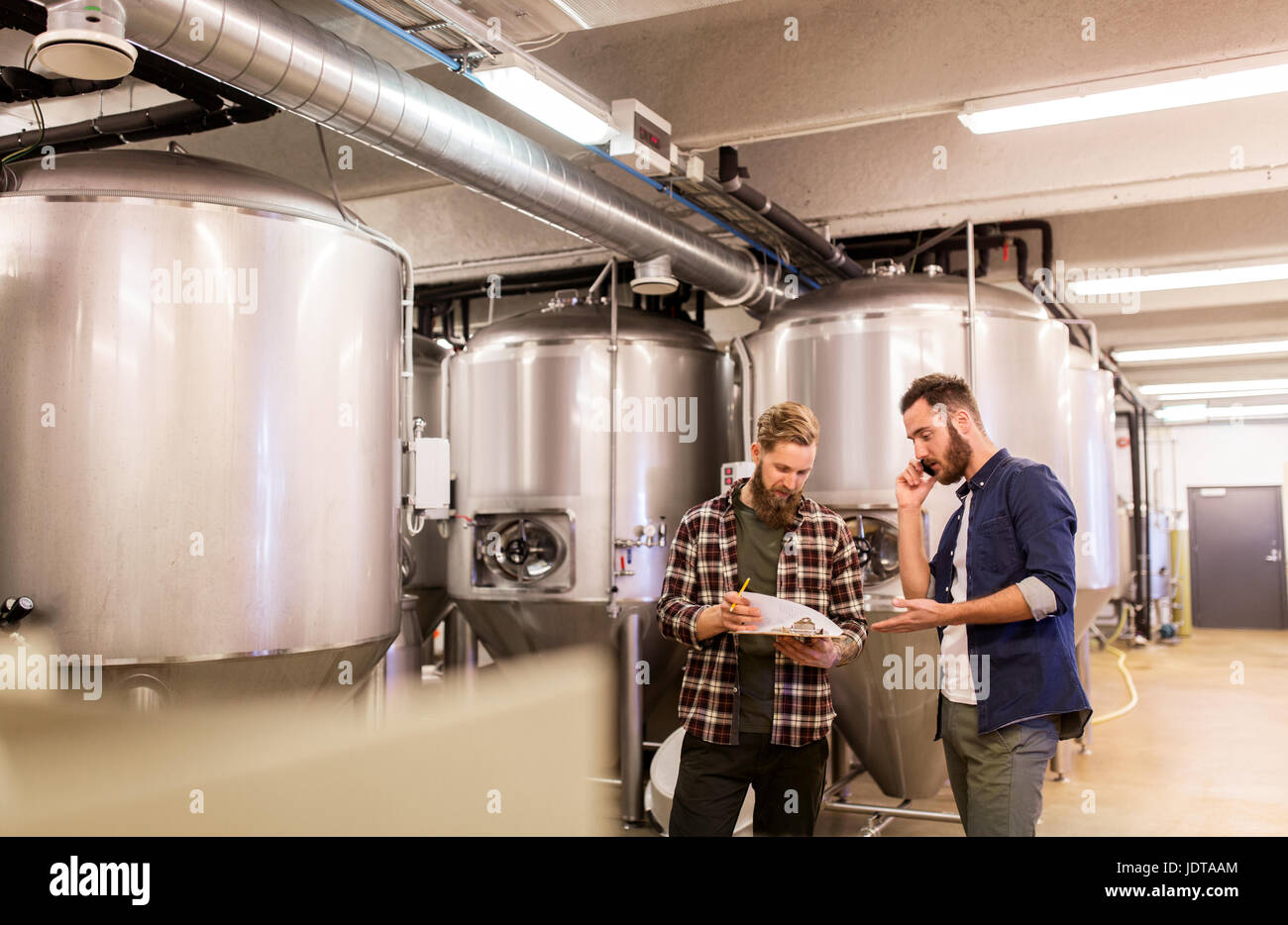 men working at craft brewery or beer plant Stock Photo - Alamy