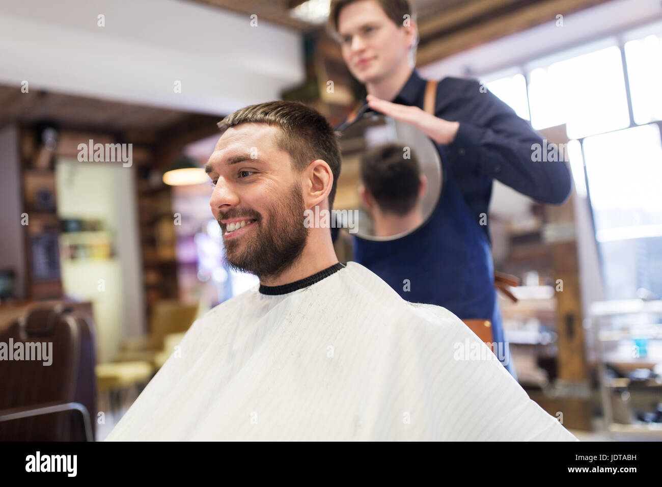 man and hairdresser with mirror at barbershop Stock Photo - Alamy