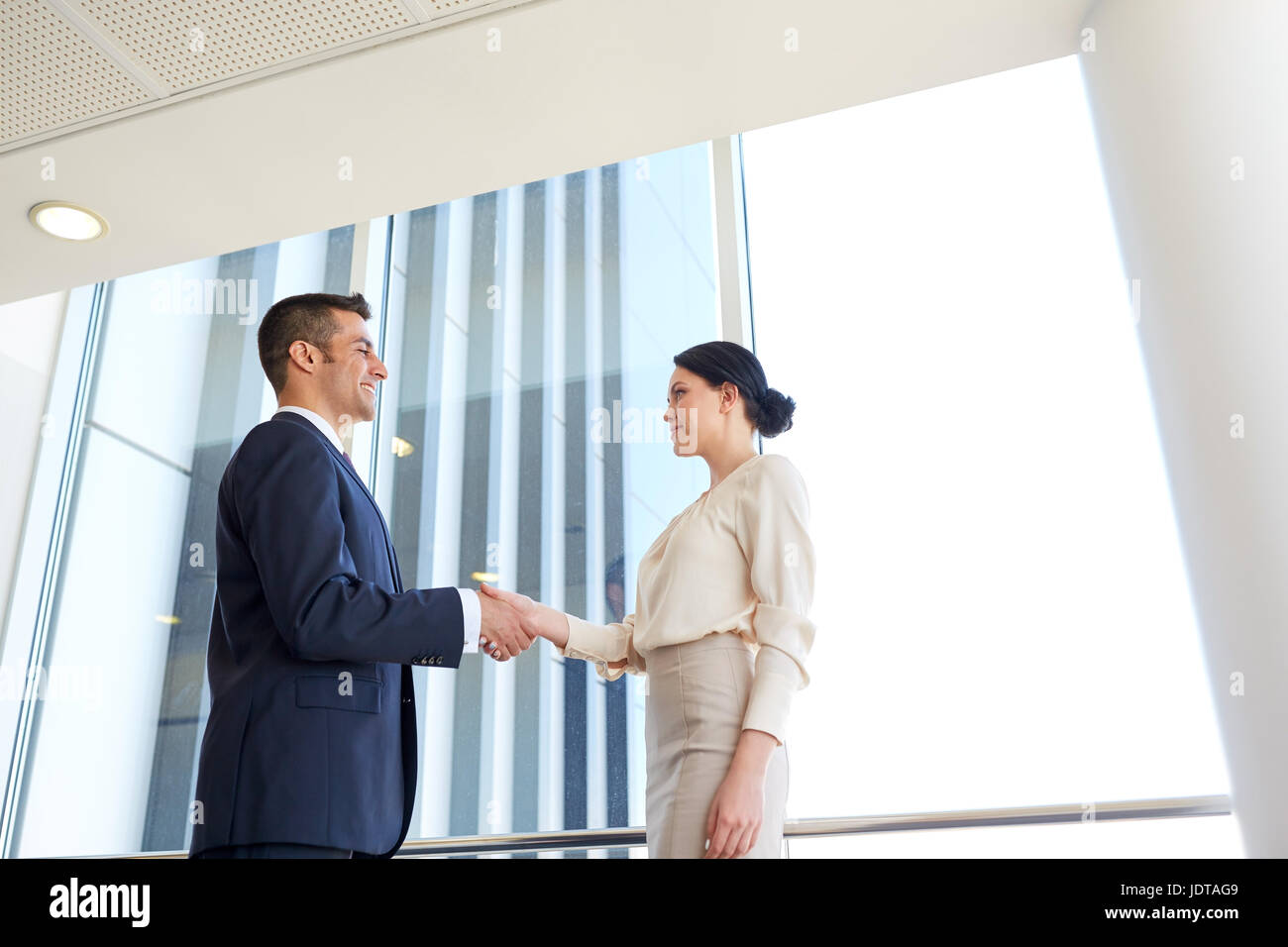smiling business people shaking hands at office Stock Photo - Alamy