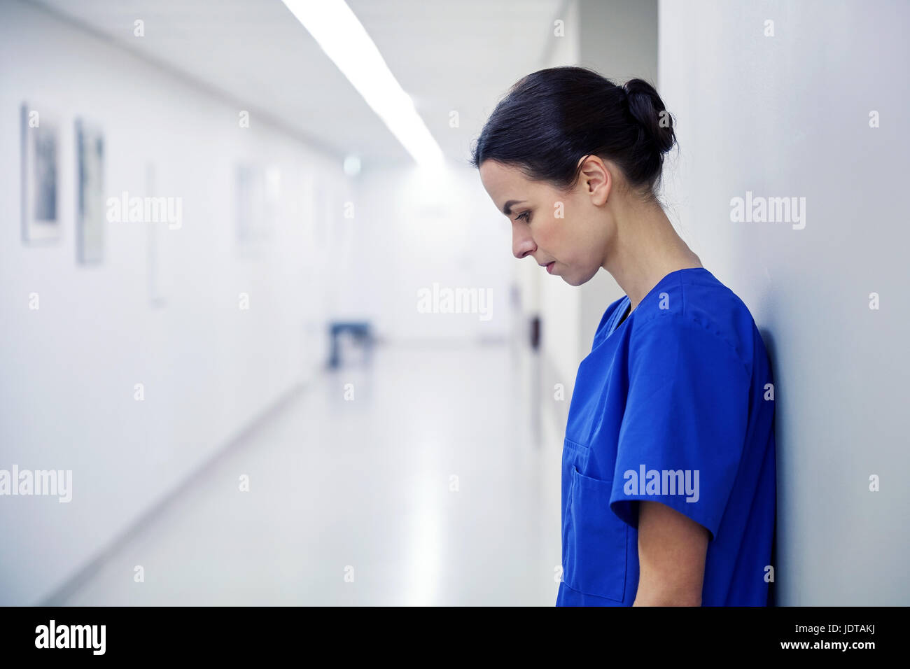 sad female nurse at hospital corridor Stock Photo - Alamy