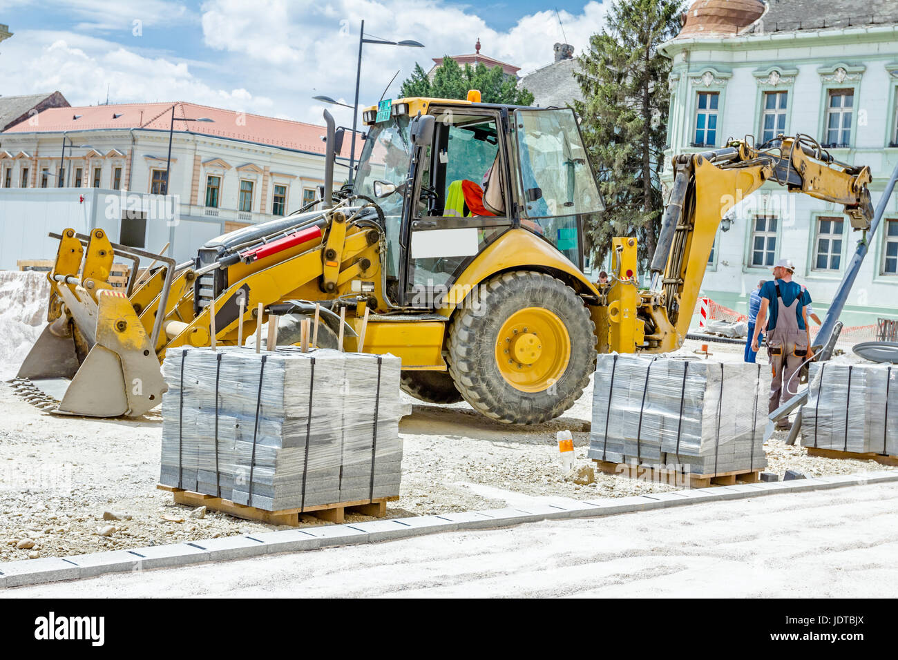 Wooden pallets with paving slabs are wrapped in plastic foil at ...