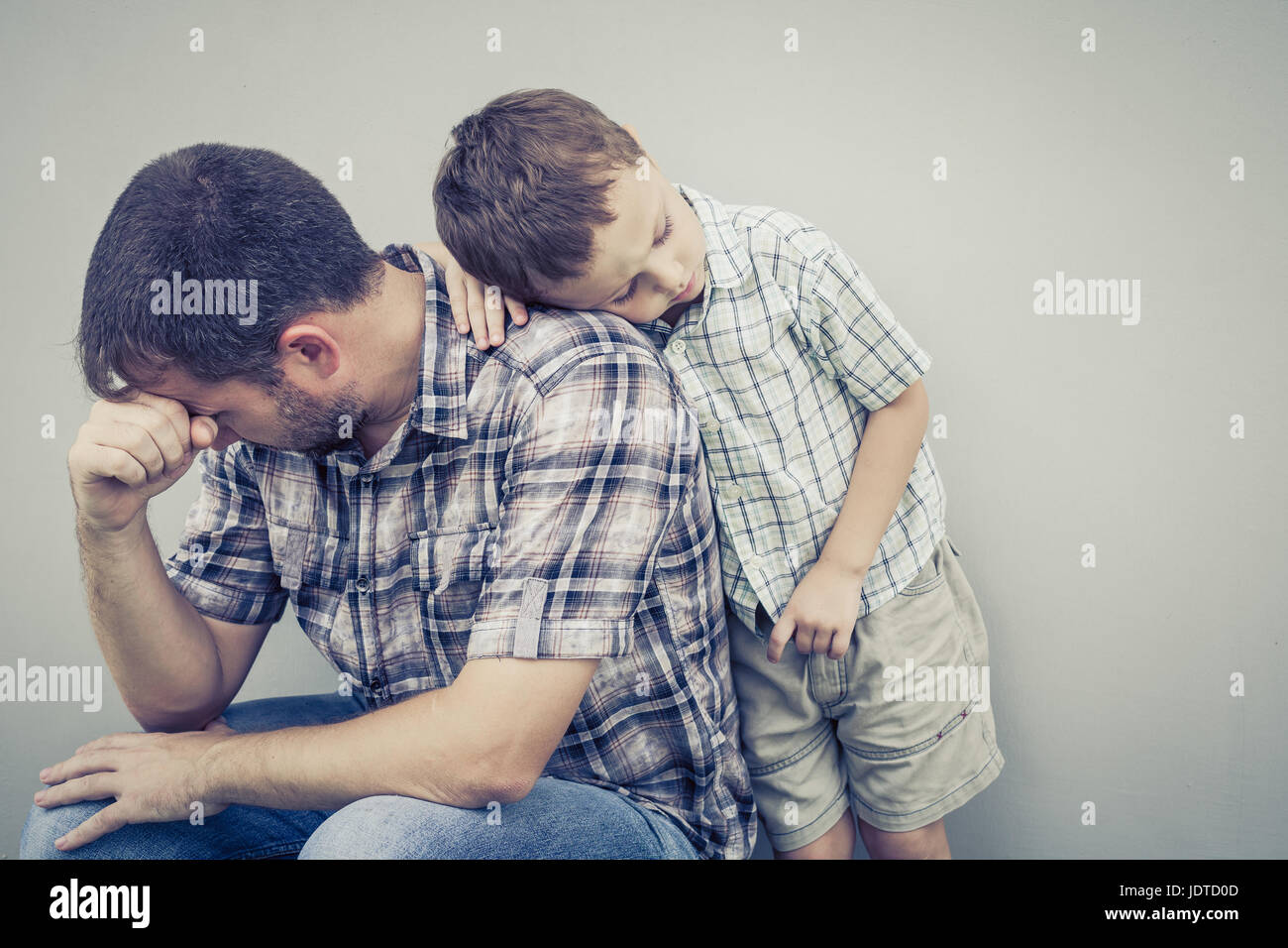 sad son hugging his dad near wall of house at the day time Stock Photo ...