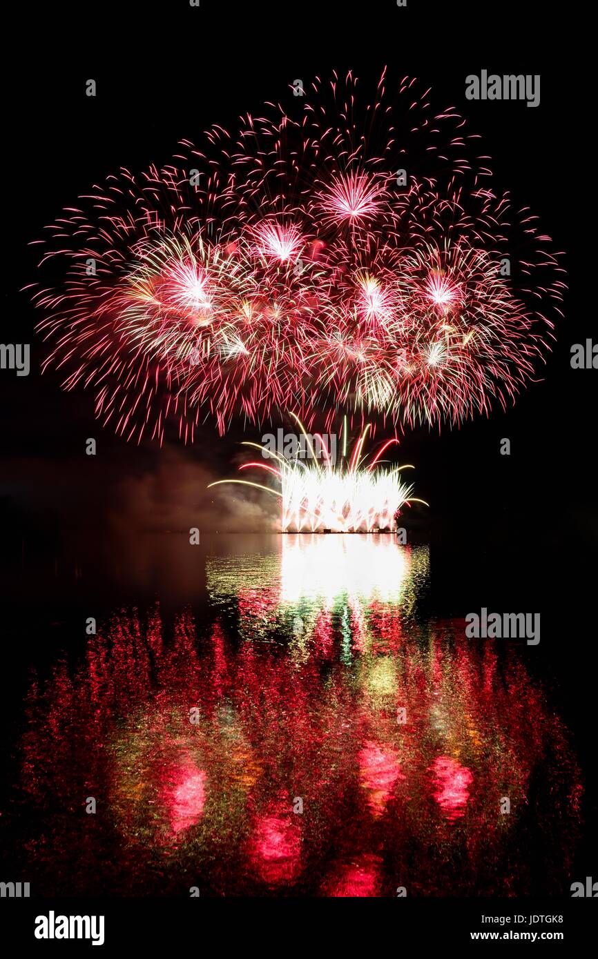 Firework. Beautiful colorful fireworks on the water surface with a ...