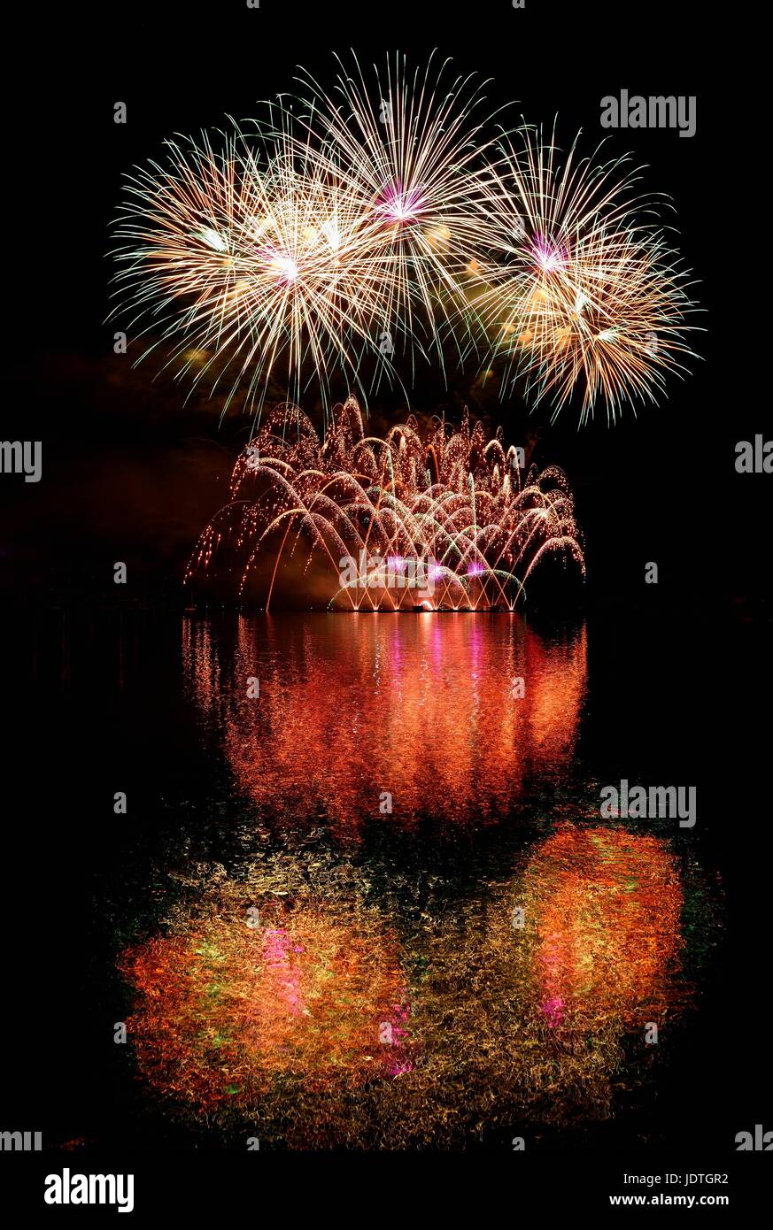Firework. Beautiful colorful fireworks on the water surface with a ...