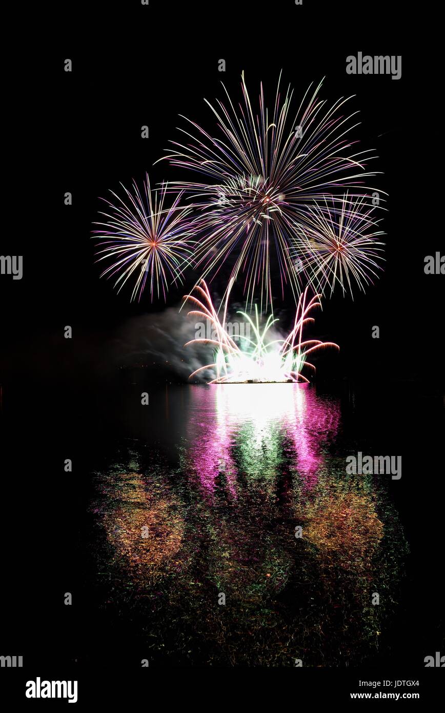 Firework. Beautiful colorful fireworks on the water surface with a ...