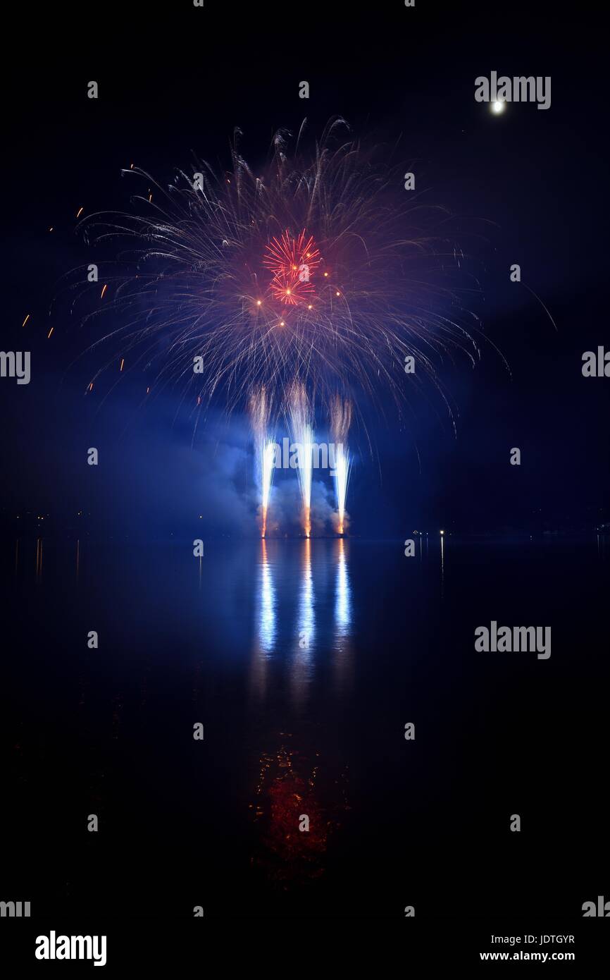 Firework. Beautiful colorful fireworks on the water surface with a ...