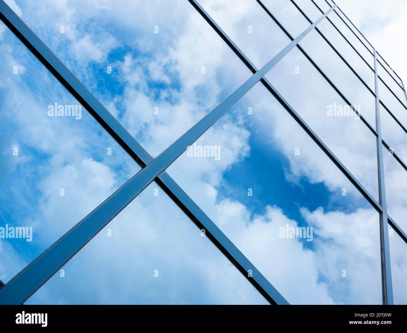 reflections of blue sky and clouds in glass facade of modern office ...