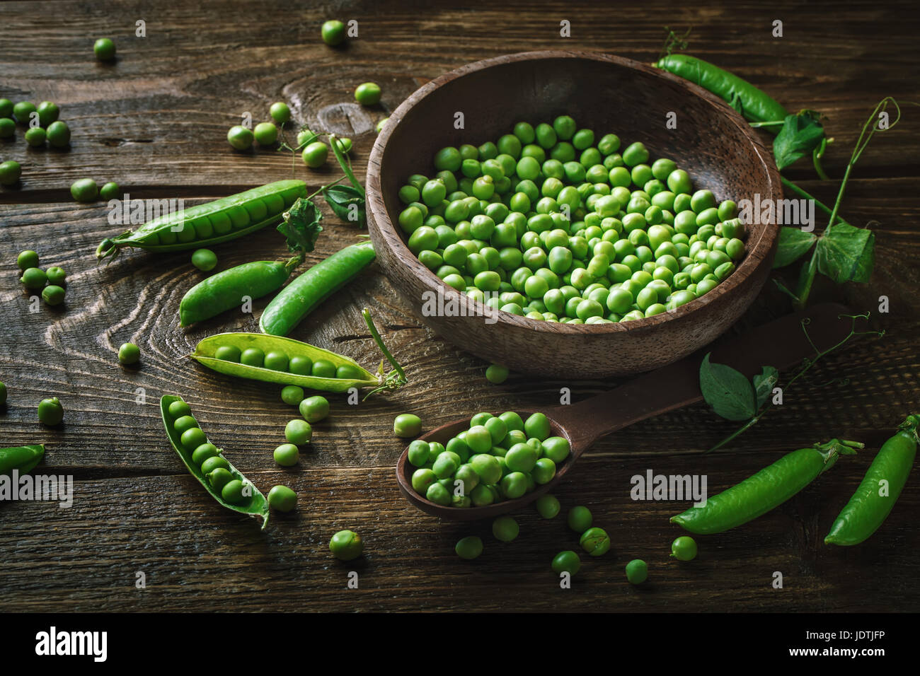 Delicious ripe green peas lying on a wooden table Stock Photo - Alamy