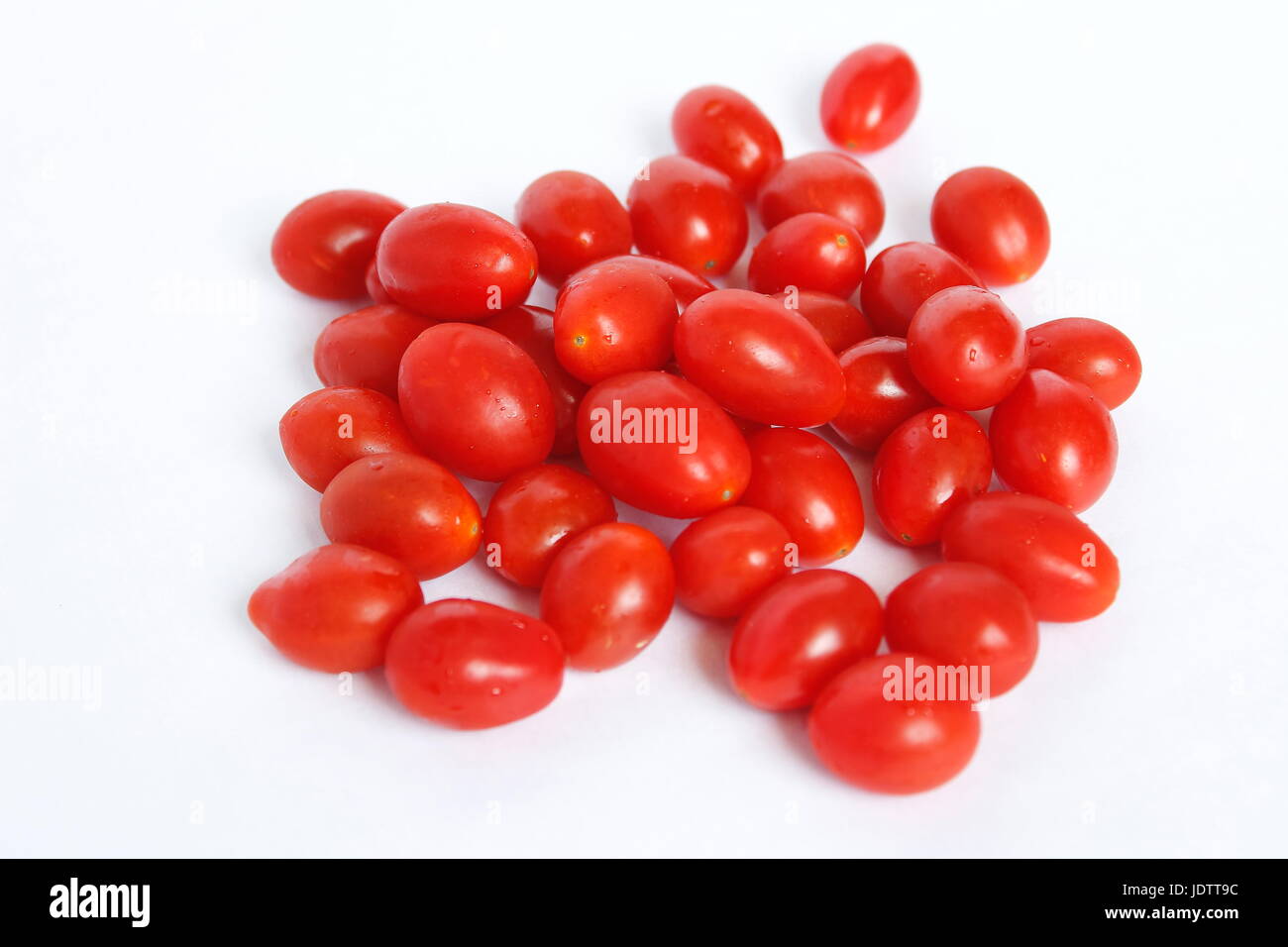 Small cherry tomatoes long red and fresh in group on white background ...