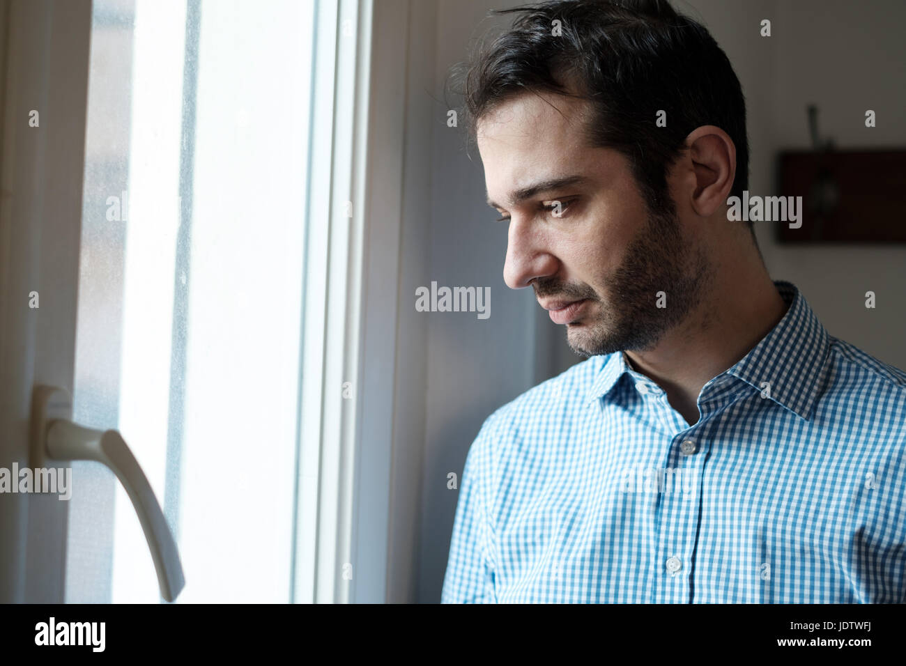 Sad man portrait looking out of the window Stock Photo - Alamy
